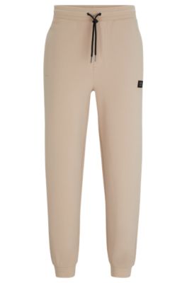 HUGO - Stretch-cotton tracksuit bottoms with stacked logo - Beige