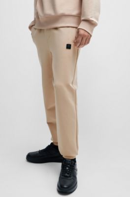 HUGO - Stretch-cotton tracksuit bottoms with stacked logo - Beige